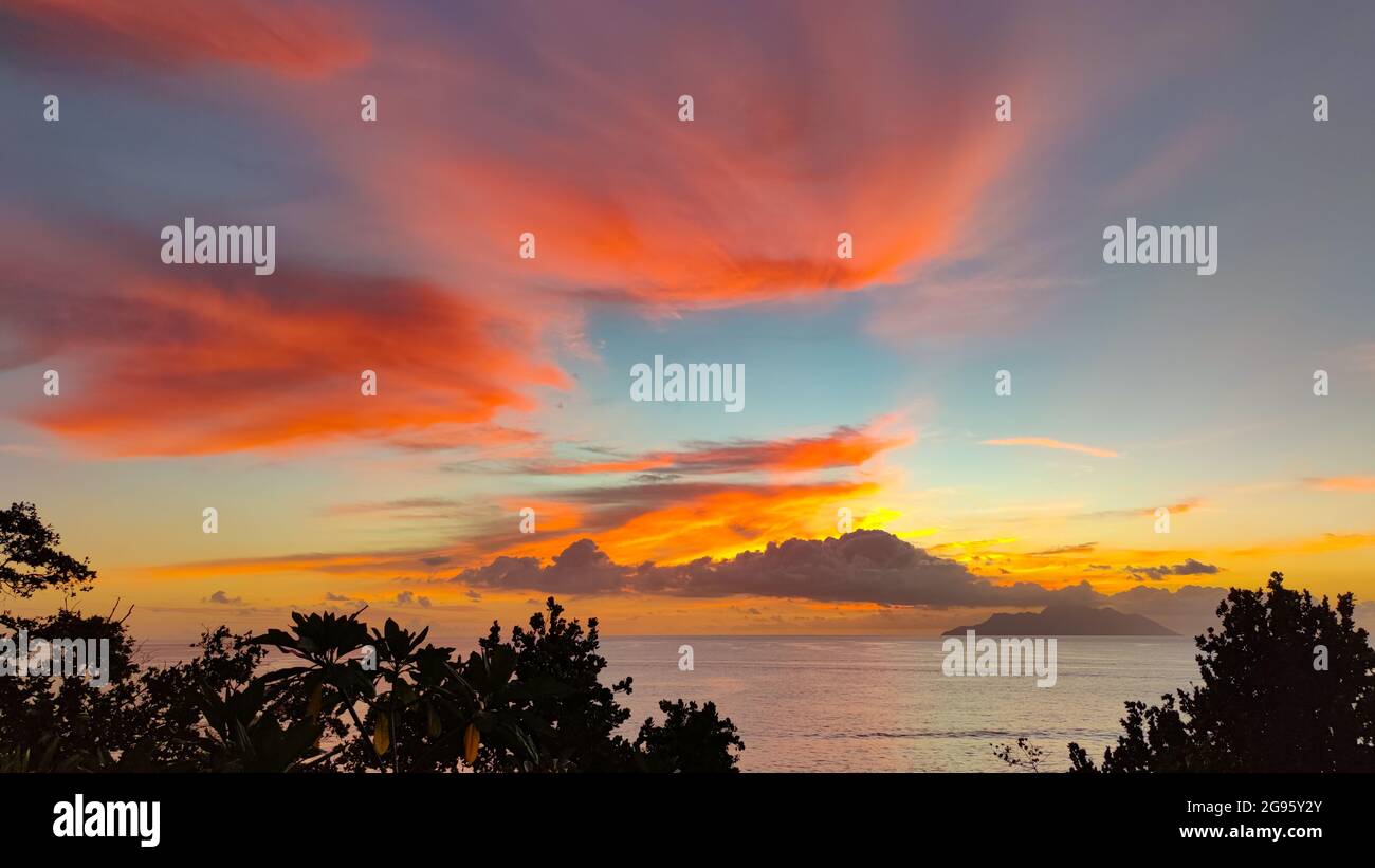 Orange and red clouds at a sunset, Mahe, Seychelles Stock Photo - Alamy
