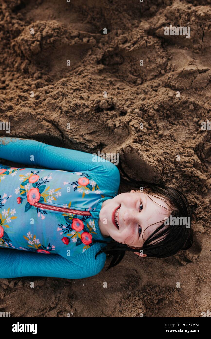 Child laying in sand hi-res stock photography and images - Alamy