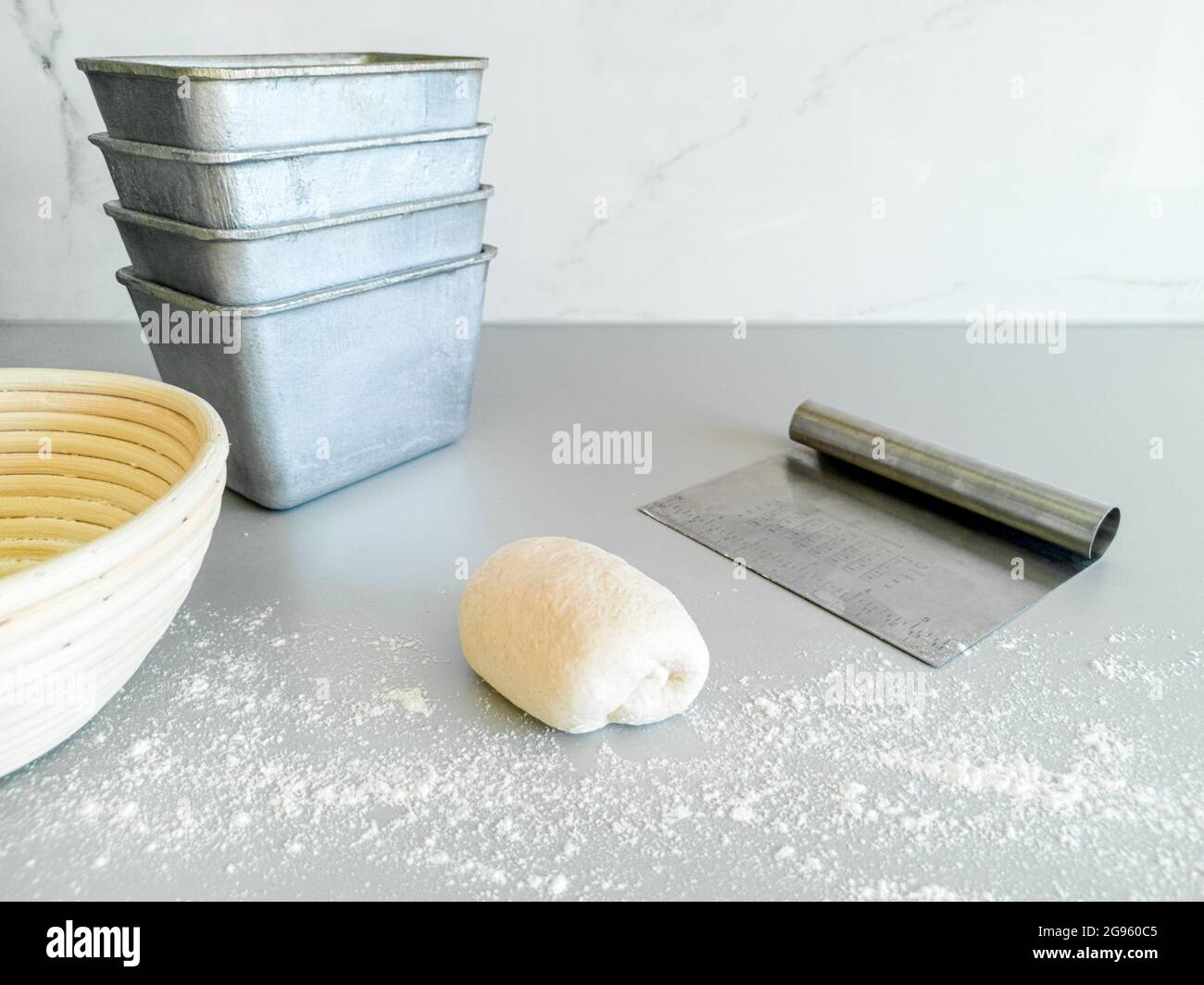 Four forms for baking bread, a piece of dough, a spatula and a basket ...