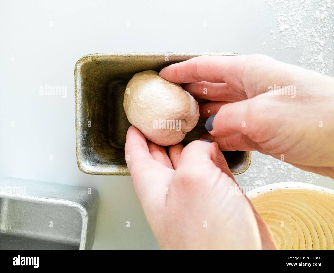 The baker's hands put the dough in the mold Stock Photo - Alamy