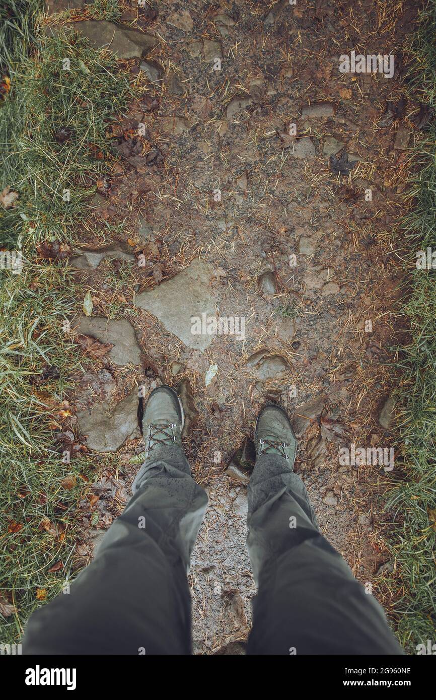 A POV of a male in hiking boots while standing on a muddy trail Stock ...