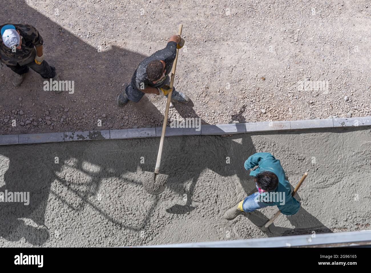 Workers leveling fresh concrete slab with a special working tool Stock ...