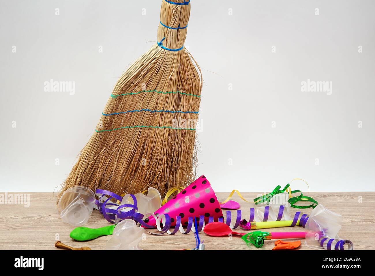 Broom sweep the trash after a party on white background close-up Stock ...