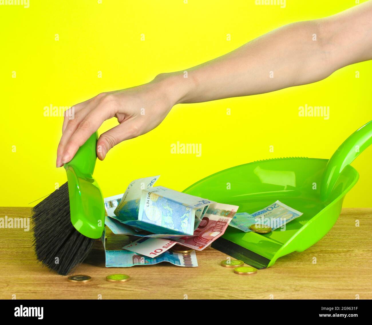Sweeps money in the shovel on colorful background close-up Stock Photo ...