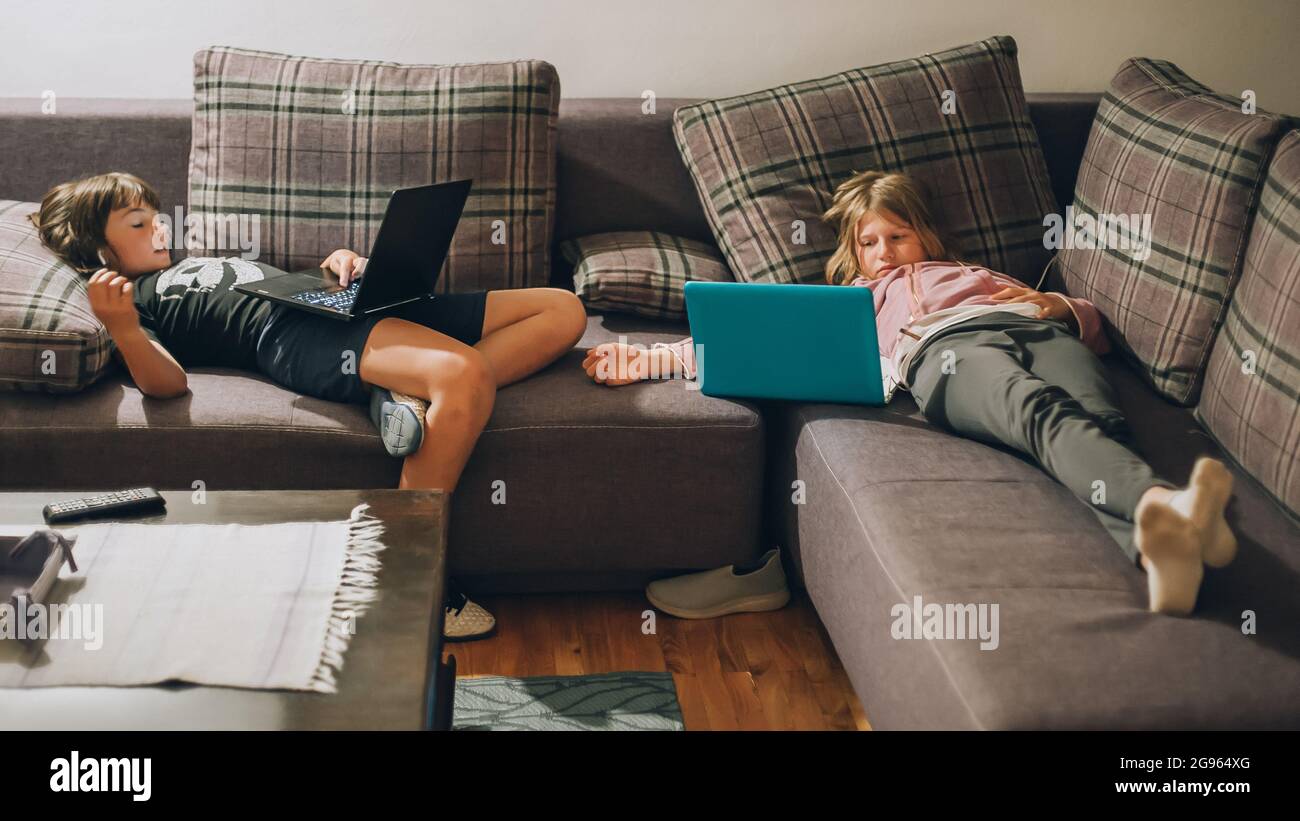 Social alienation of teenagers. Two children using laptop at home ...
