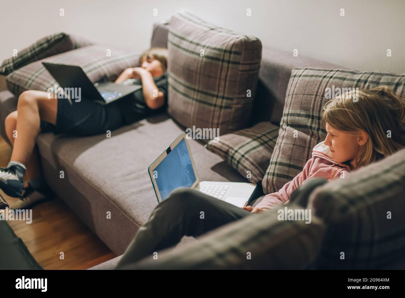 Social alienation of teenagers. Two children using laptop at home ...