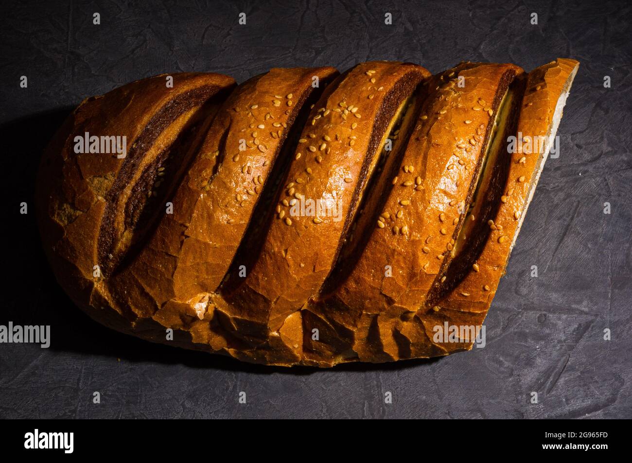 Unusual two-color fresh loaf of bread on a black background, photo in a ...