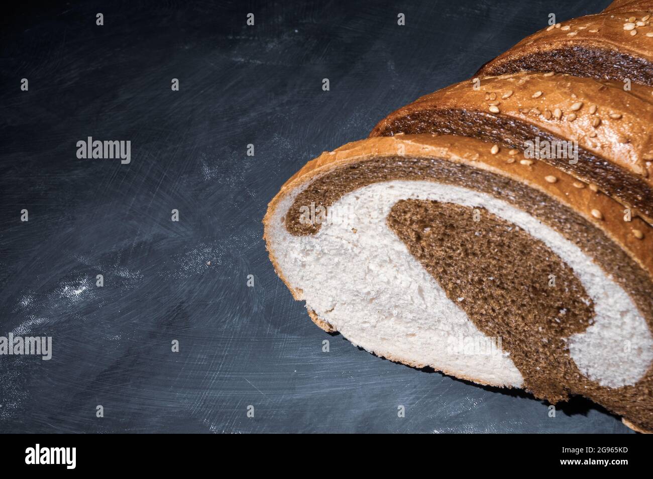 Unusual two-color fresh loaf of bread on a black background, photo in a ...
