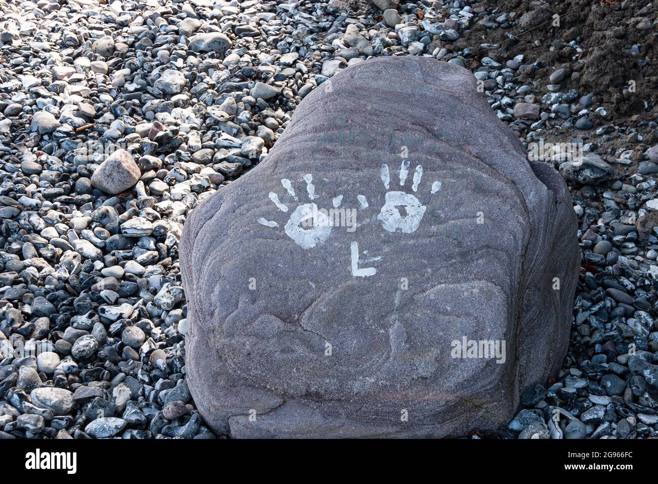 On the coast of Rügen is painted on a stone a face of two hands and a ...