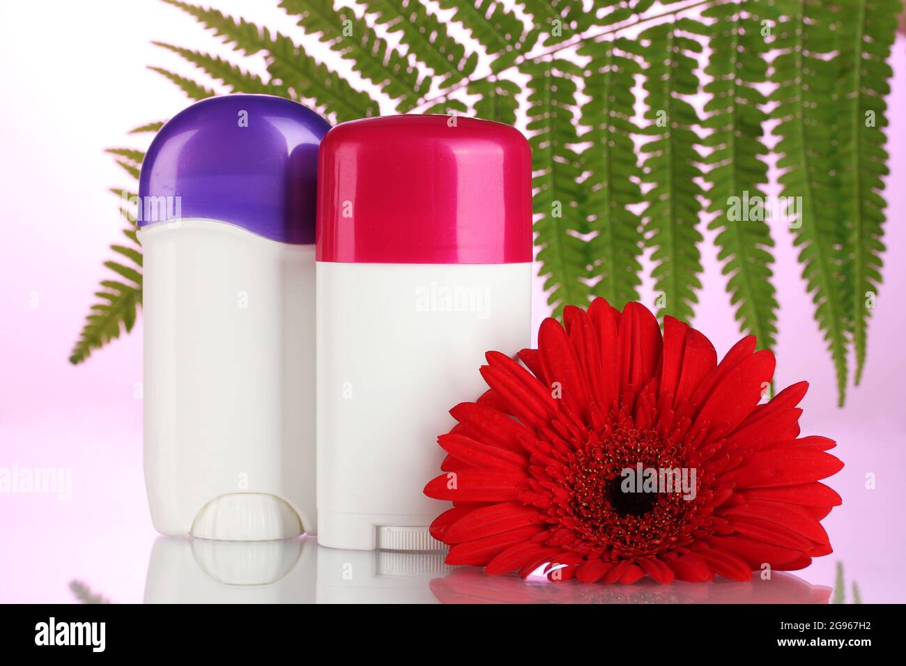 deodorants with flower and green leaf on pink background Stock Photo ...