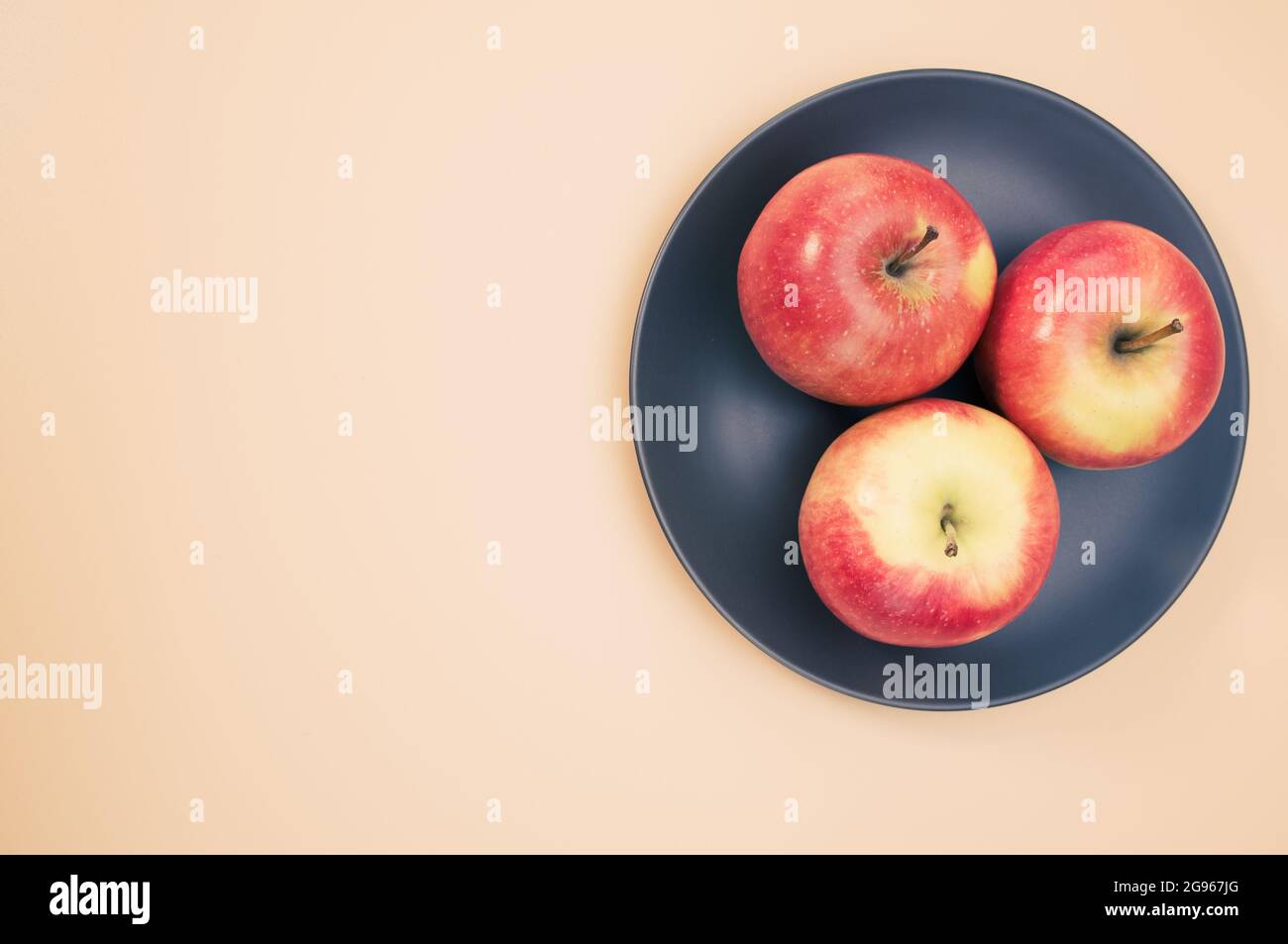 Top view of apples on a plate isolated on light cream background Stock ...