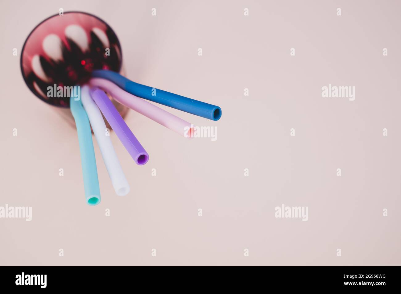Top view of colorful stainless straw on a glass isolated on a light ...