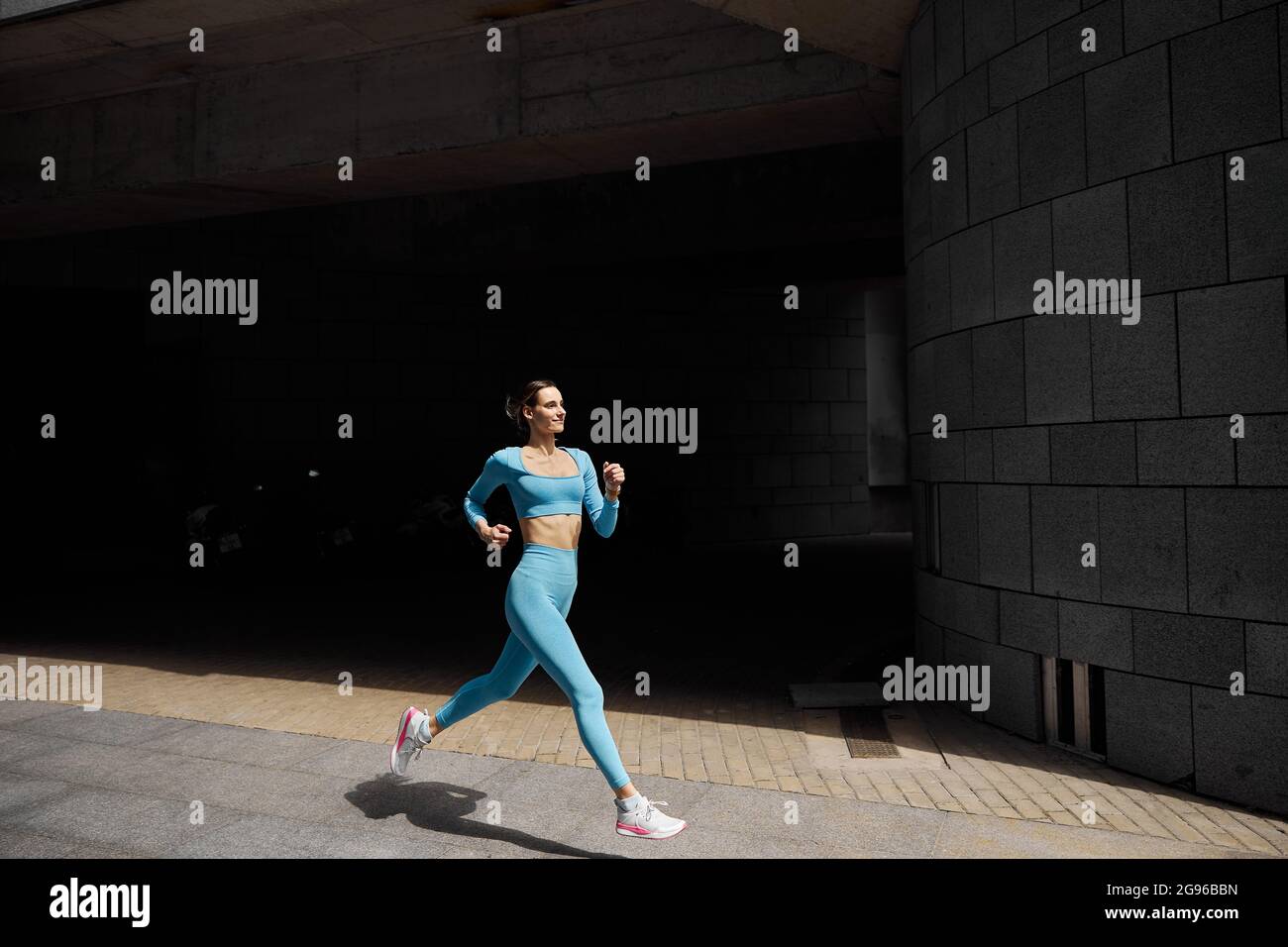 Beautiful fit young woman jogger is running outdoors Stock Photo - Alamy