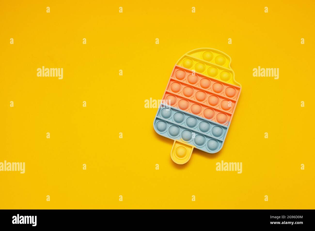 Rainbow antistress Pop it fidget toy on yellow background with copy ...