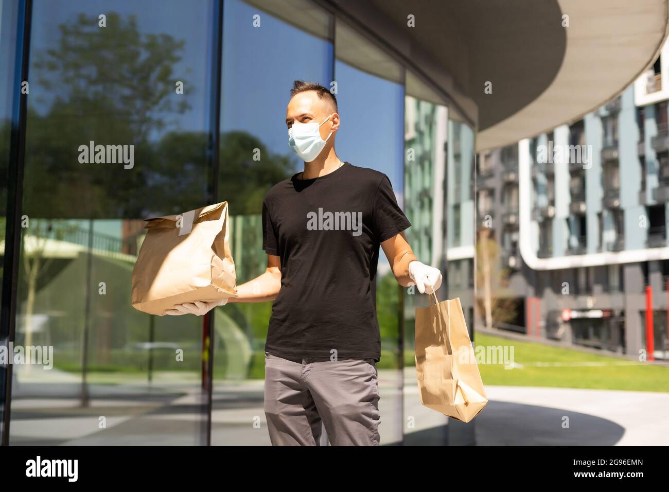 delivery guy in protective mask near the customer house, outdoors Stock ...
