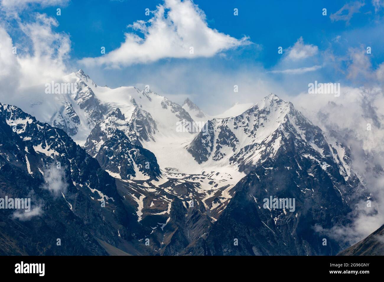 High mountain peaks covered in snow under a bright sk Stock Photo - Alamy
