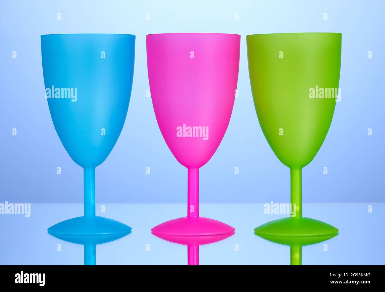 Bright plastic goblets on blue background Stock Photo - Alamy
