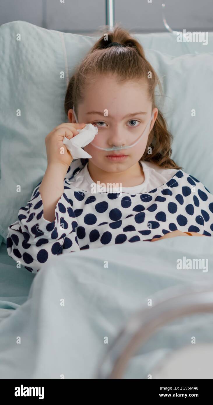 Portrait of sick vulnerable alone little child looking into camera ...