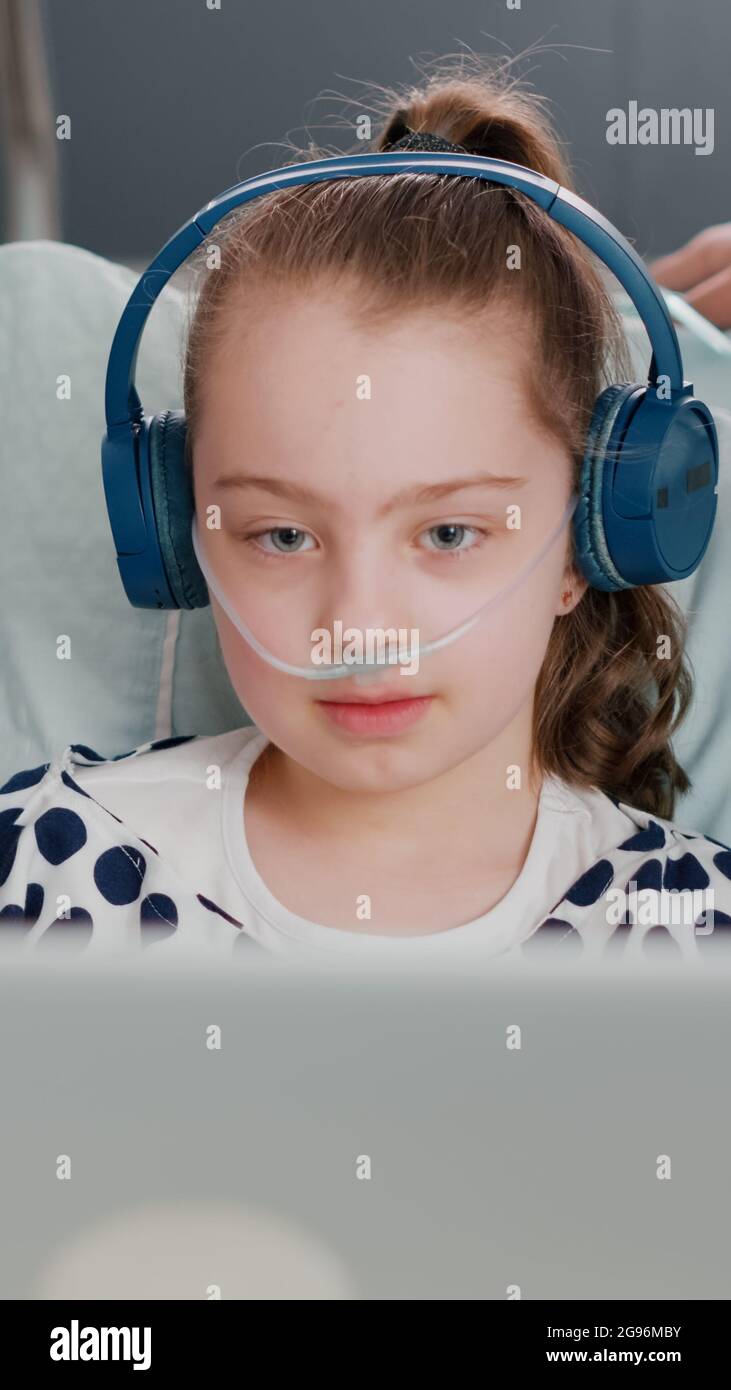 Family sitting beside daughter while playing online videogames using ...