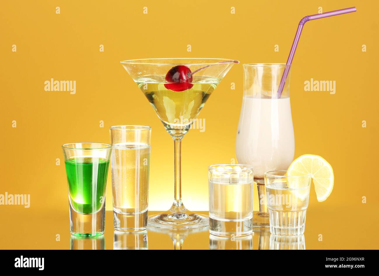 a variety of alcoholic drinks on yellow background Stock Photo - Alamy