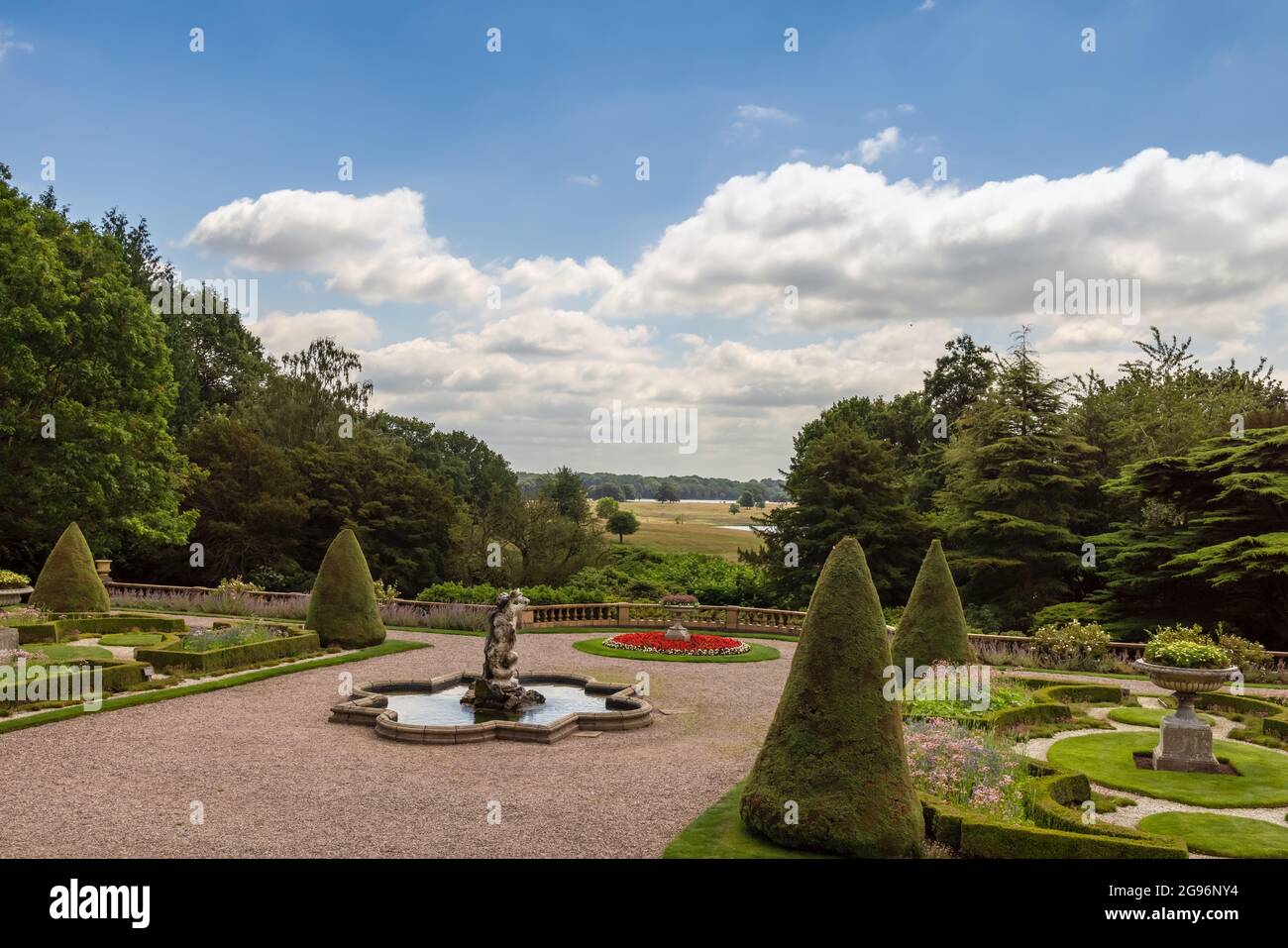 Topiary, flower beds and small fountain in a formal garden in a park in ...