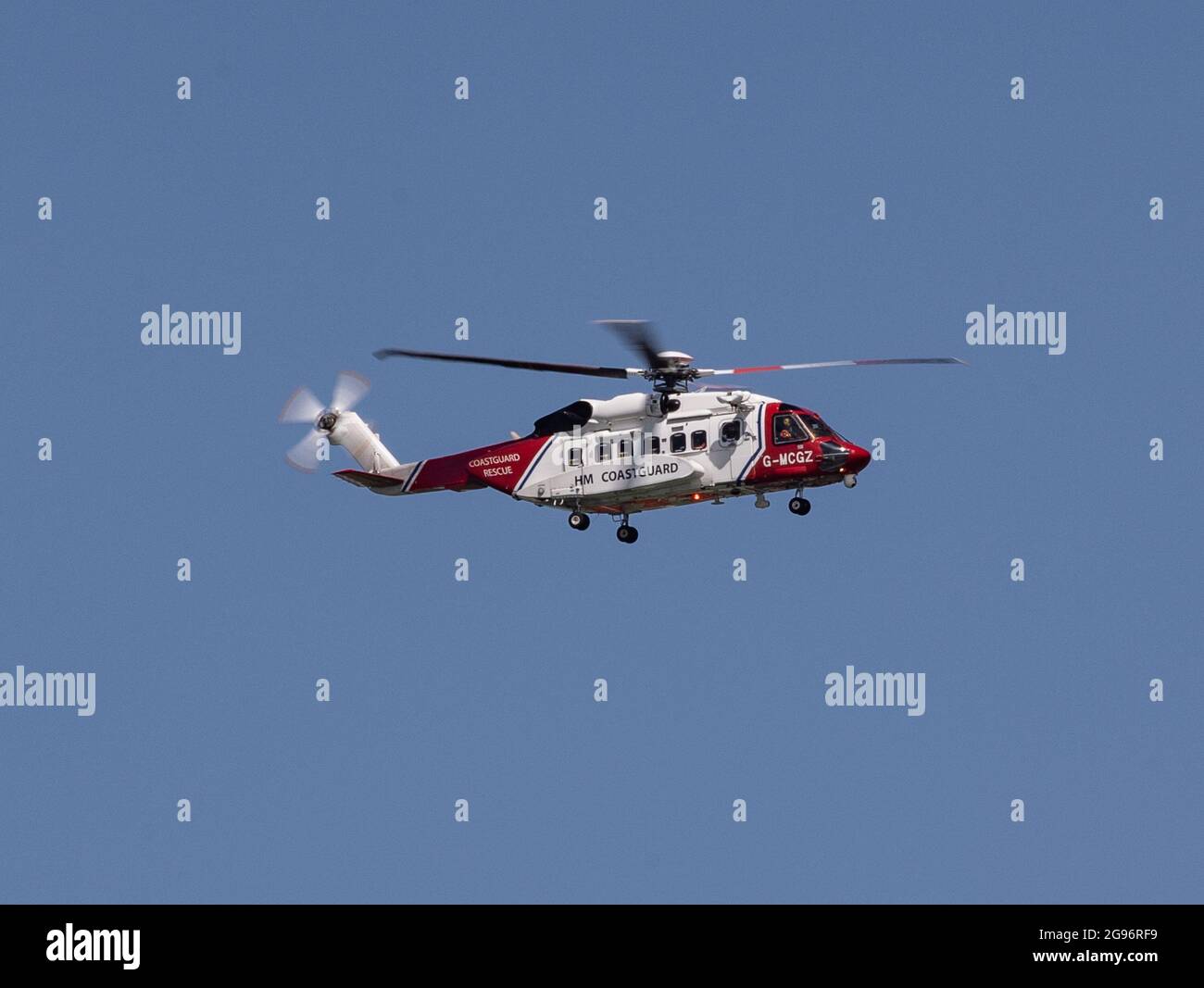Red white helicopter flying on the air with clear blue sky background ...