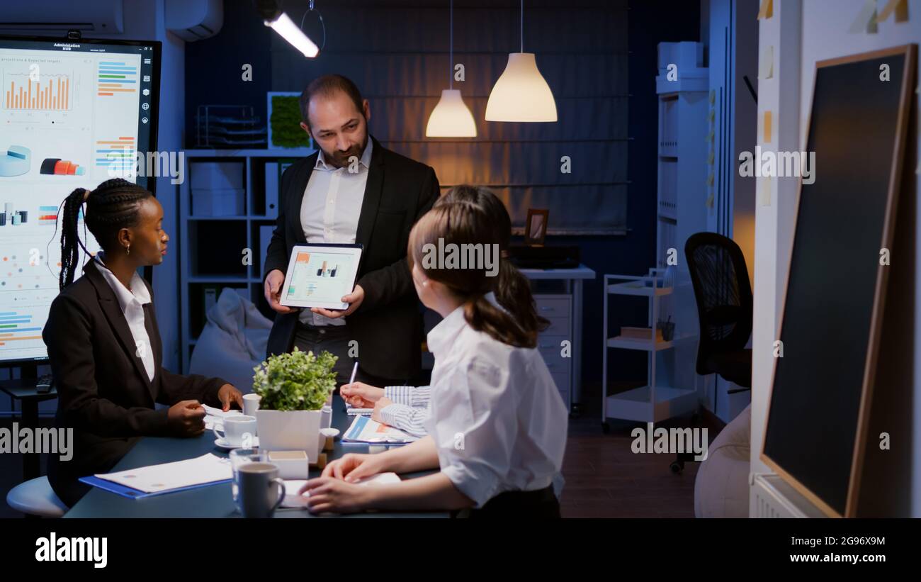 Overworked businessman showing financial graphs presentation using ...