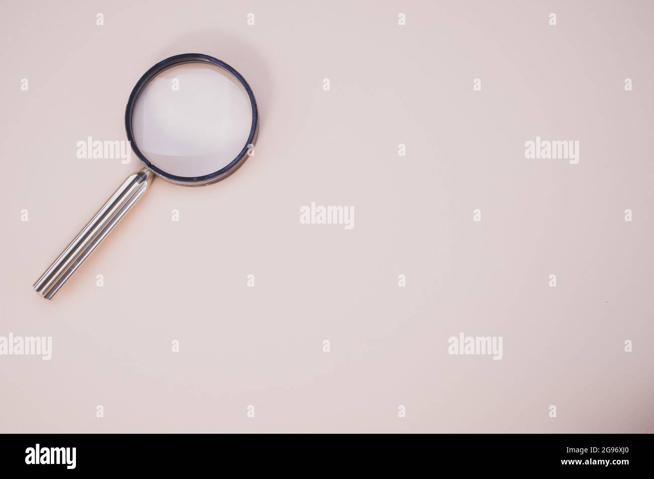 Top view of magnifying glass isolated on a light cream background with ...