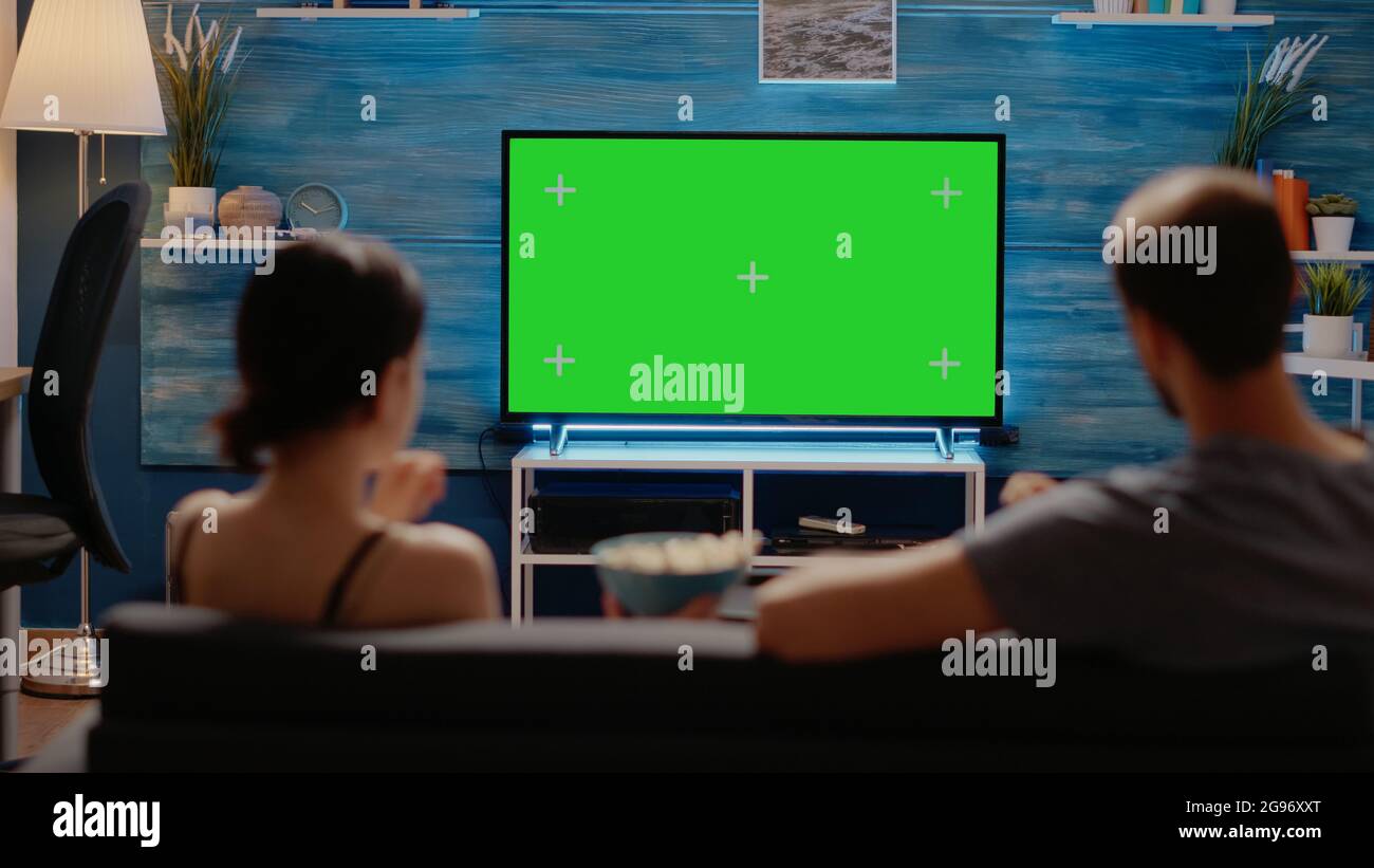 Caucasian people watching green screen layout on tv display in living ...