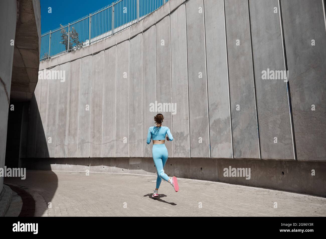 Beautiful fit young woman jogger is running outdoors Stock Photo - Alamy