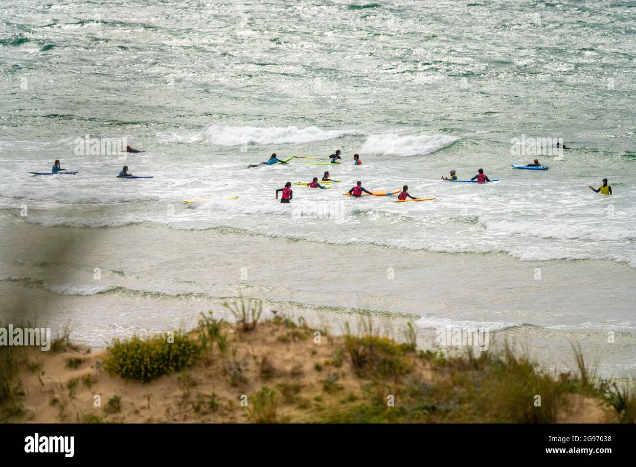 People walking with surfboards and surfing, in the city of Somo in the ...