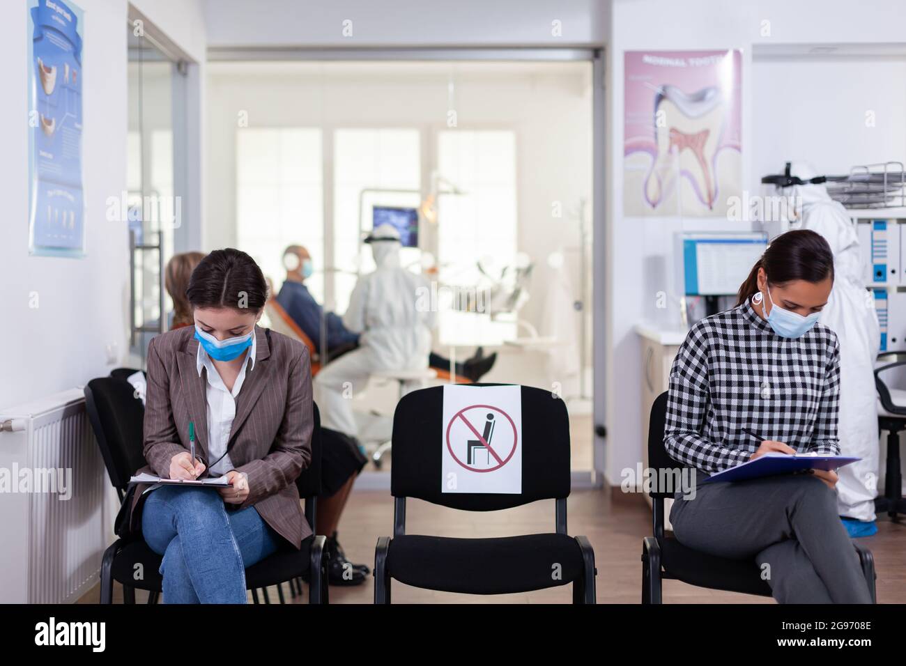 Patient with face protection mask writing on registration form in ...