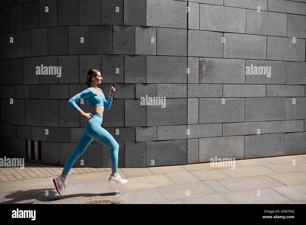 Beautiful fit young woman jogger is running outdoors Stock Photo - Alamy