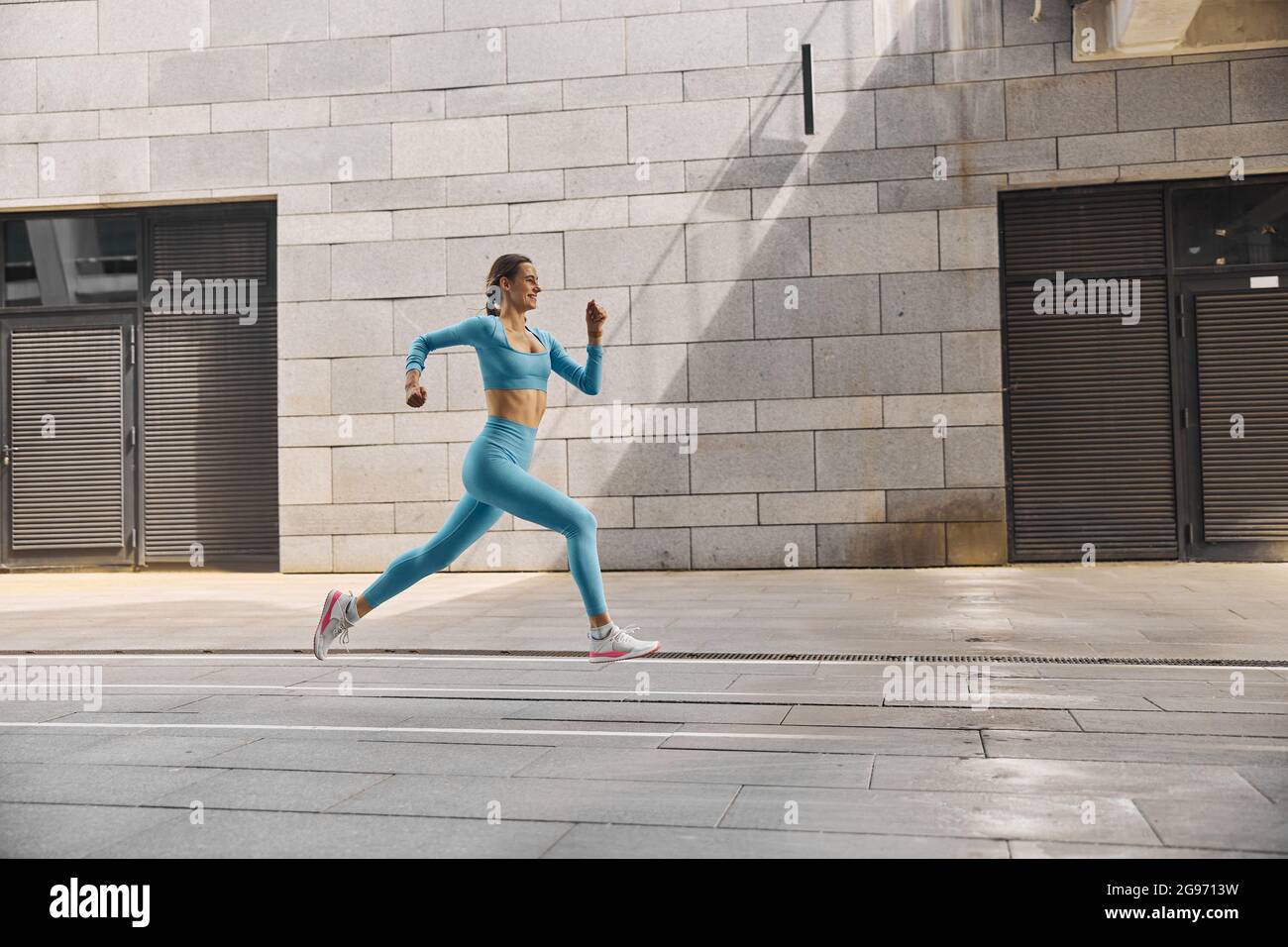 Beautiful fit young woman jogger is running outdoors Stock Photo - Alamy