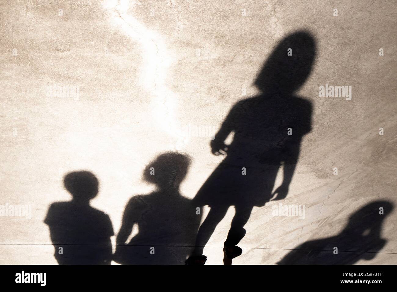 Blurry shadow silhouette of a little girl walking alone on a summer day ...