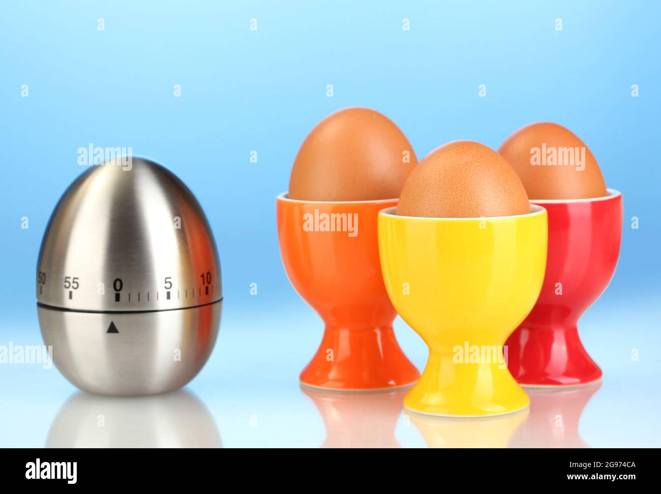 egg timer and egg in color stand on blue background Stock Photo - Alamy