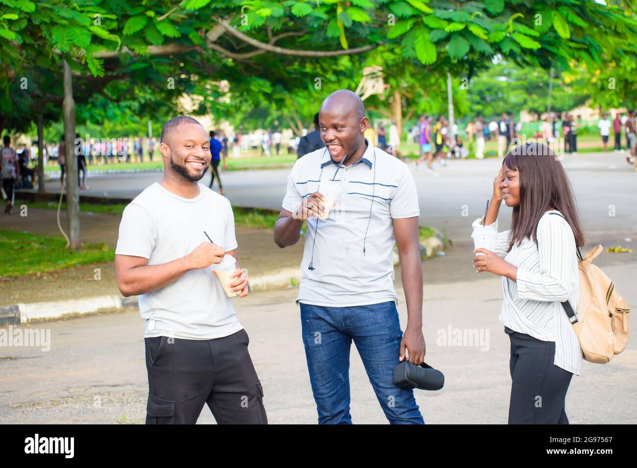 African friends consisting of two guys and a lady joyfully happily ...