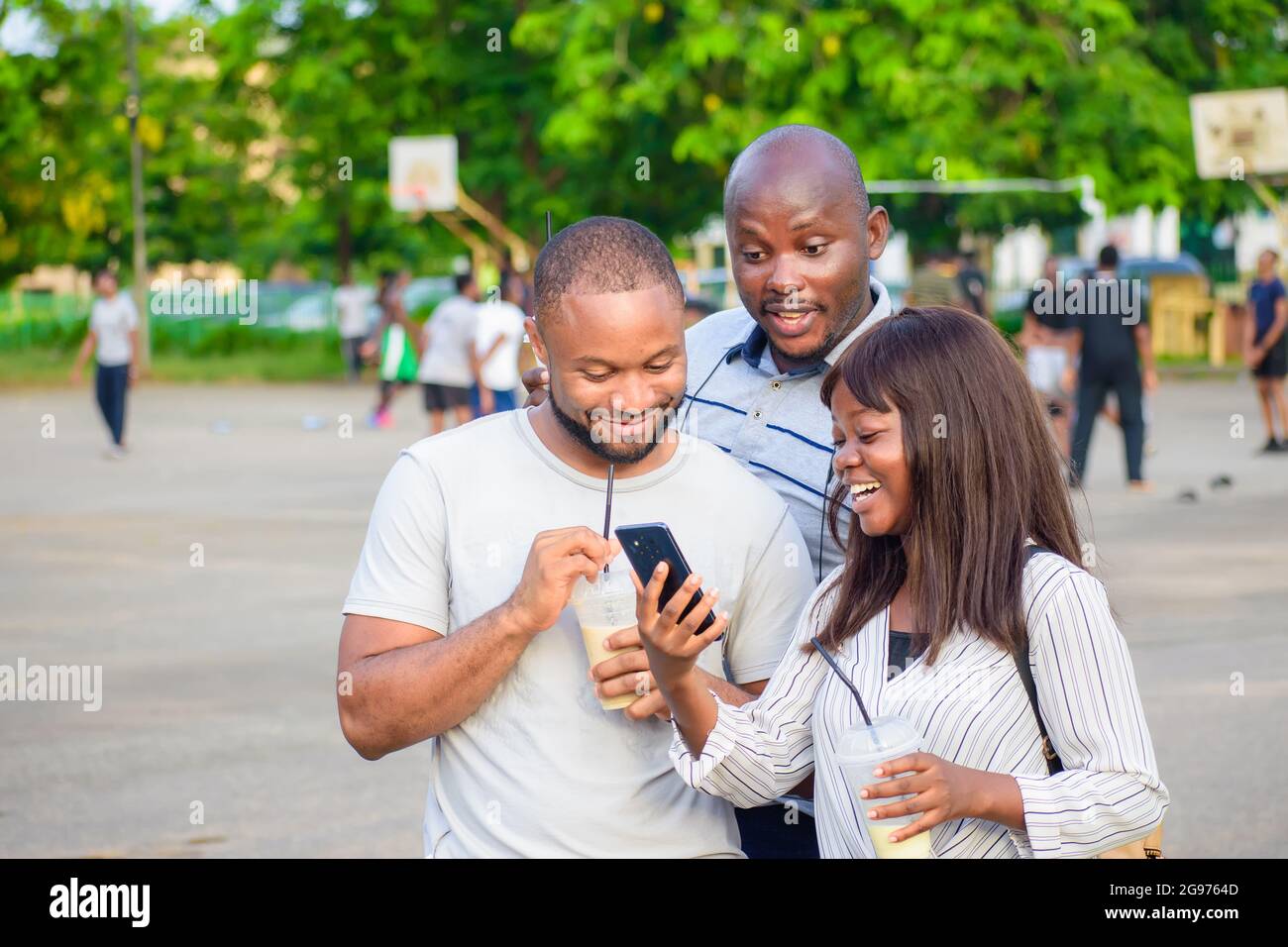 happy group of African friends consisting of two guys and a lady ...
