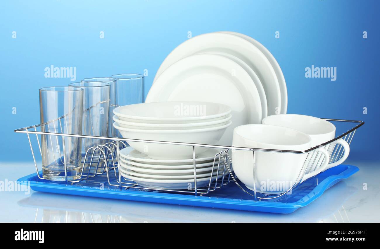 clean dishes on stand on blue background Stock Photo - Alamy