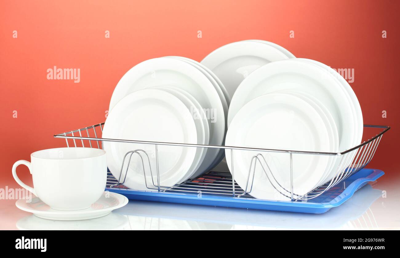 clean dishes on stand on red background Stock Photo - Alamy