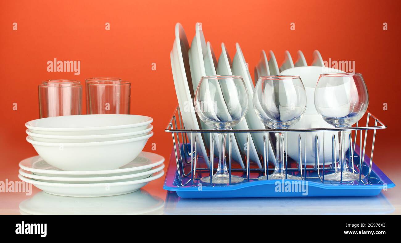 clean dishes on stand on red background Stock Photo - Alamy