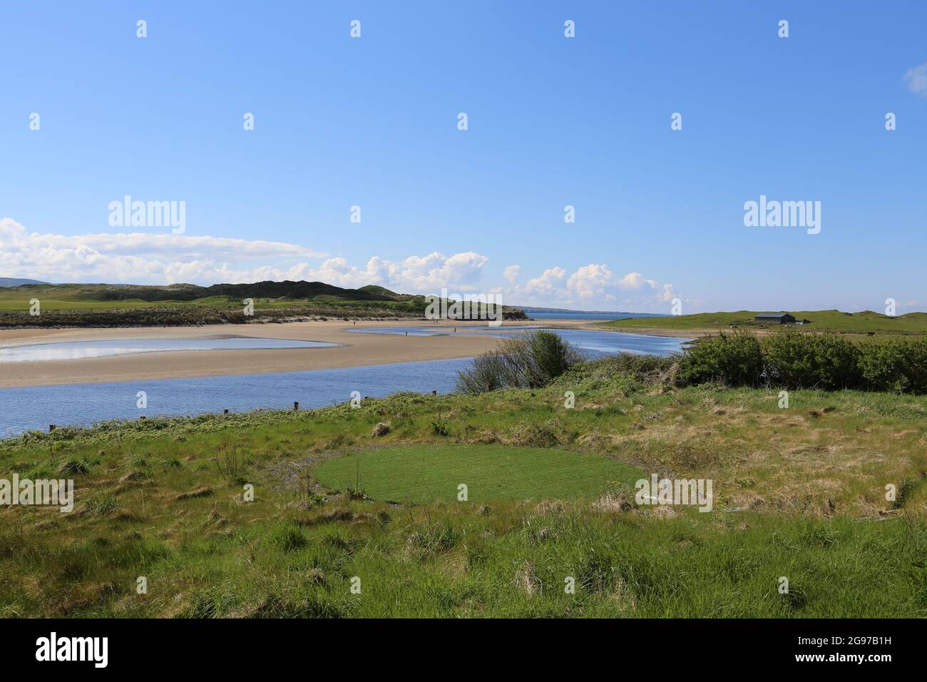 A beautiful view of a flowing river surrounded by greens gleaming under ...