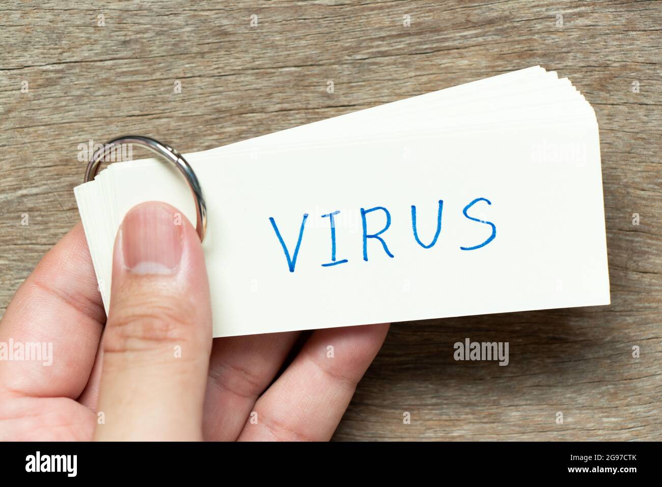 Man hold the flash card with handwriting word virus on wood background ...