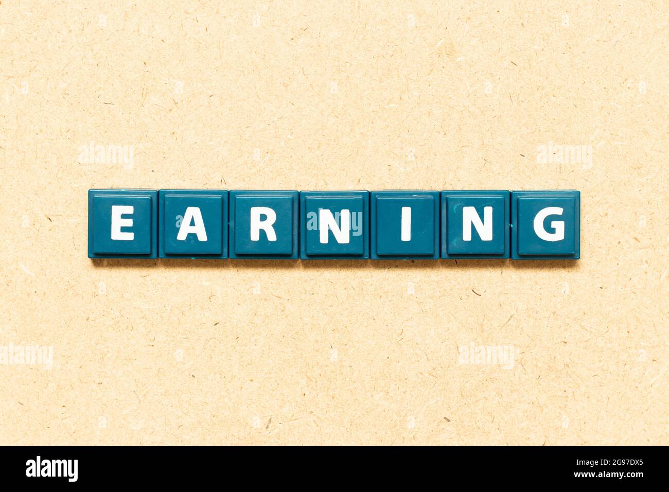Tile alphabet letter in word earning on wood background Stock Photo - Alamy