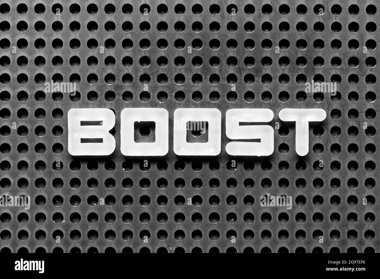 White alphabet letter in word boost on black pegboard background Stock ...