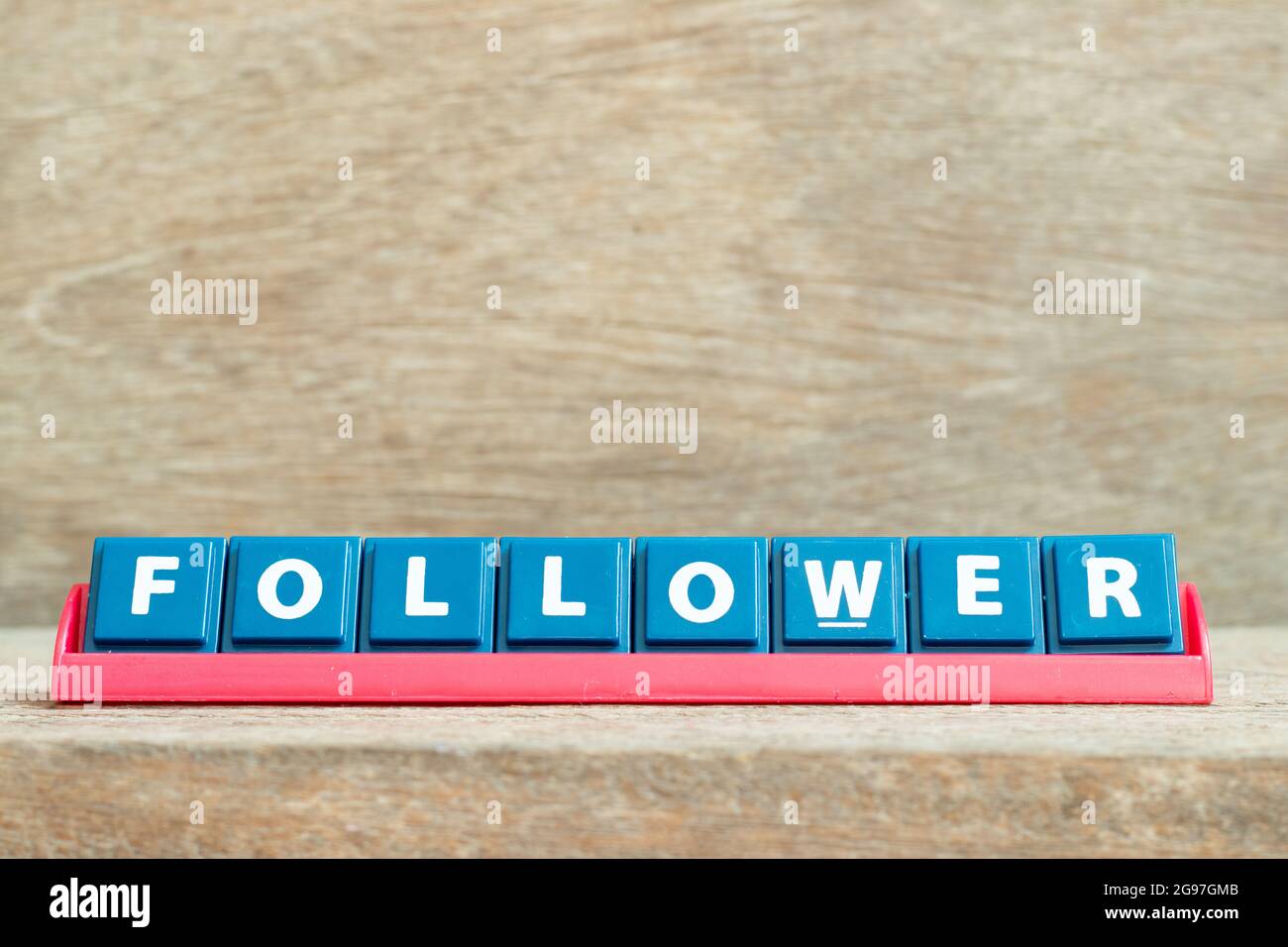 Tile alphabet letter with word follower in red color rack on wood ...