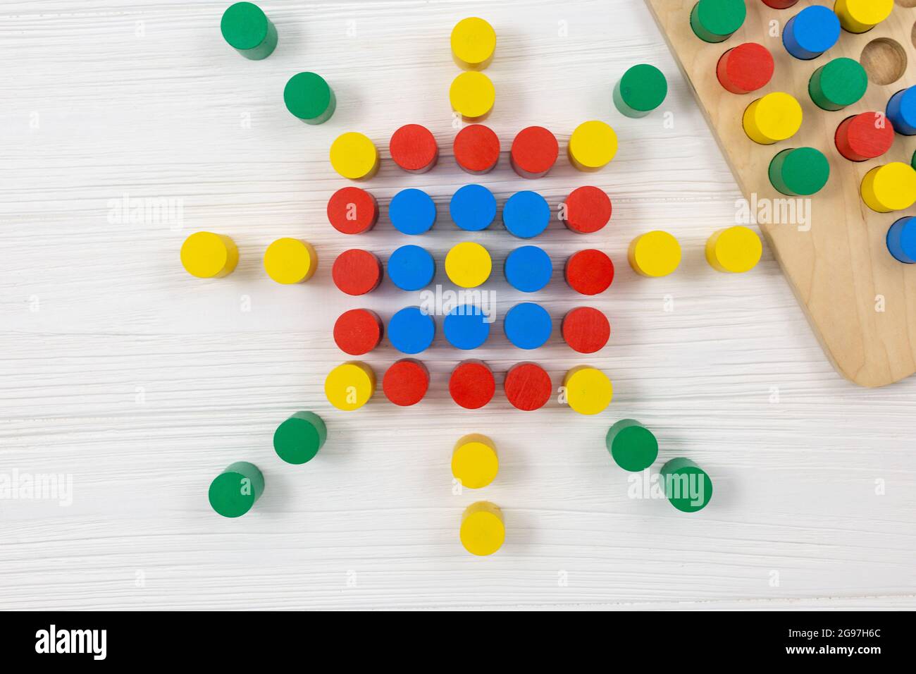 Colorful toy flower with wooden blocks for children on a white table ...