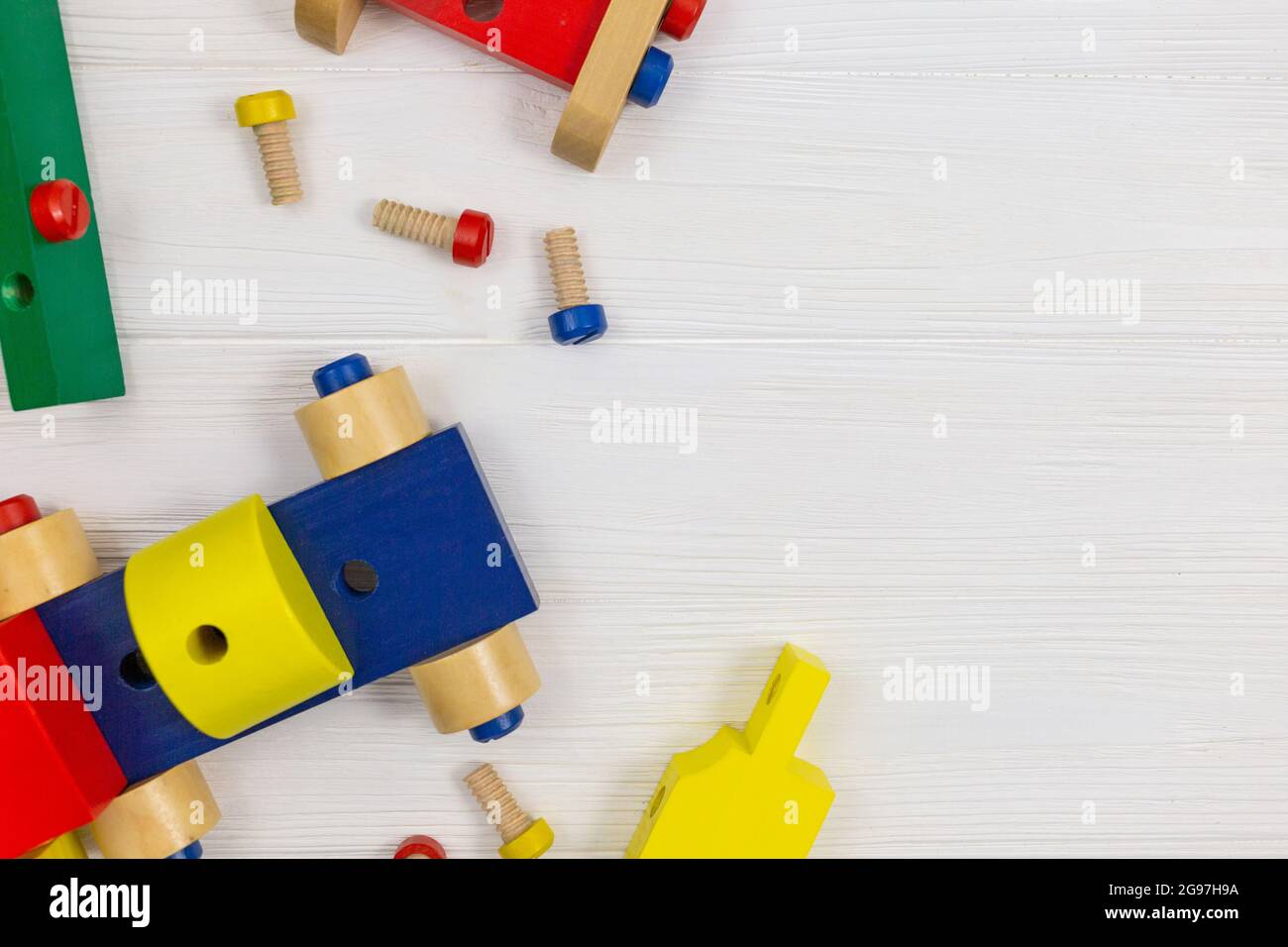 A colorful wooden building kit for children on wood. Set of tools on ...