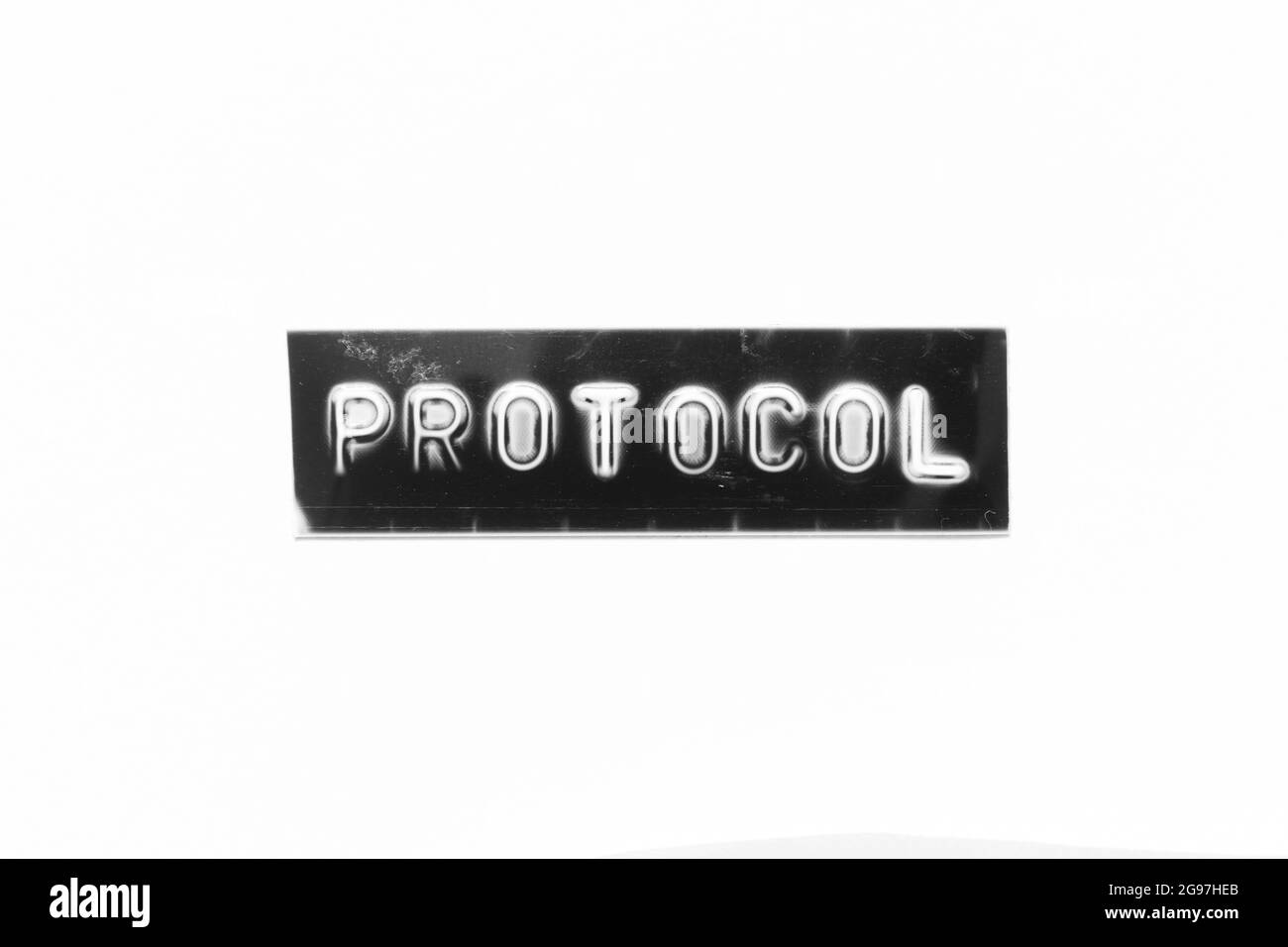 Embossed letter with word protocol in black banner on white paper ...