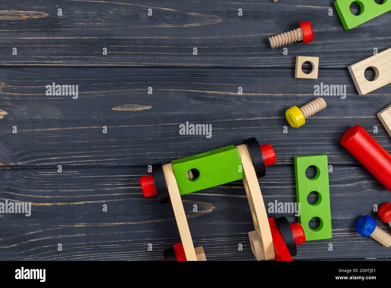 A colorful wooden building kit for children on wood. Set of tools on ...